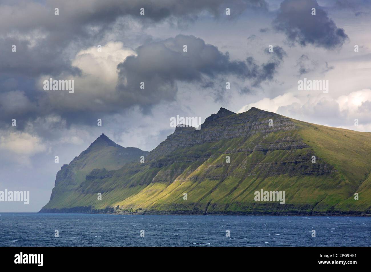 Sea cliffs along the rugged coast of Eysturoy / East Island, region and ...