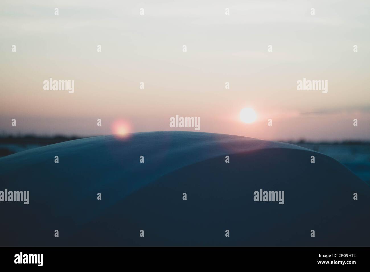 Frosty winter sunset in the field. Beautiful sunset in the snowy desert ...