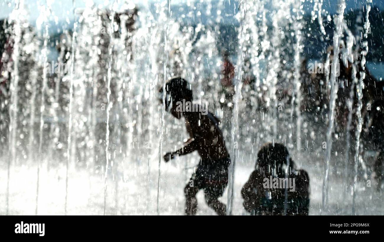 Blurred little boy running at water park jets. Child having fun during ...