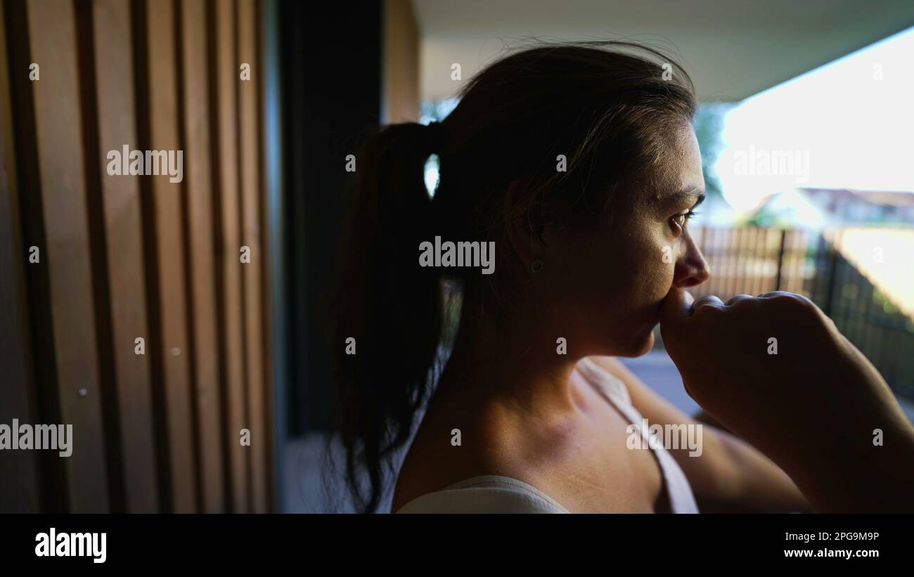 Contemplative woman thinking deeply at apartment balcony. Pensive ...