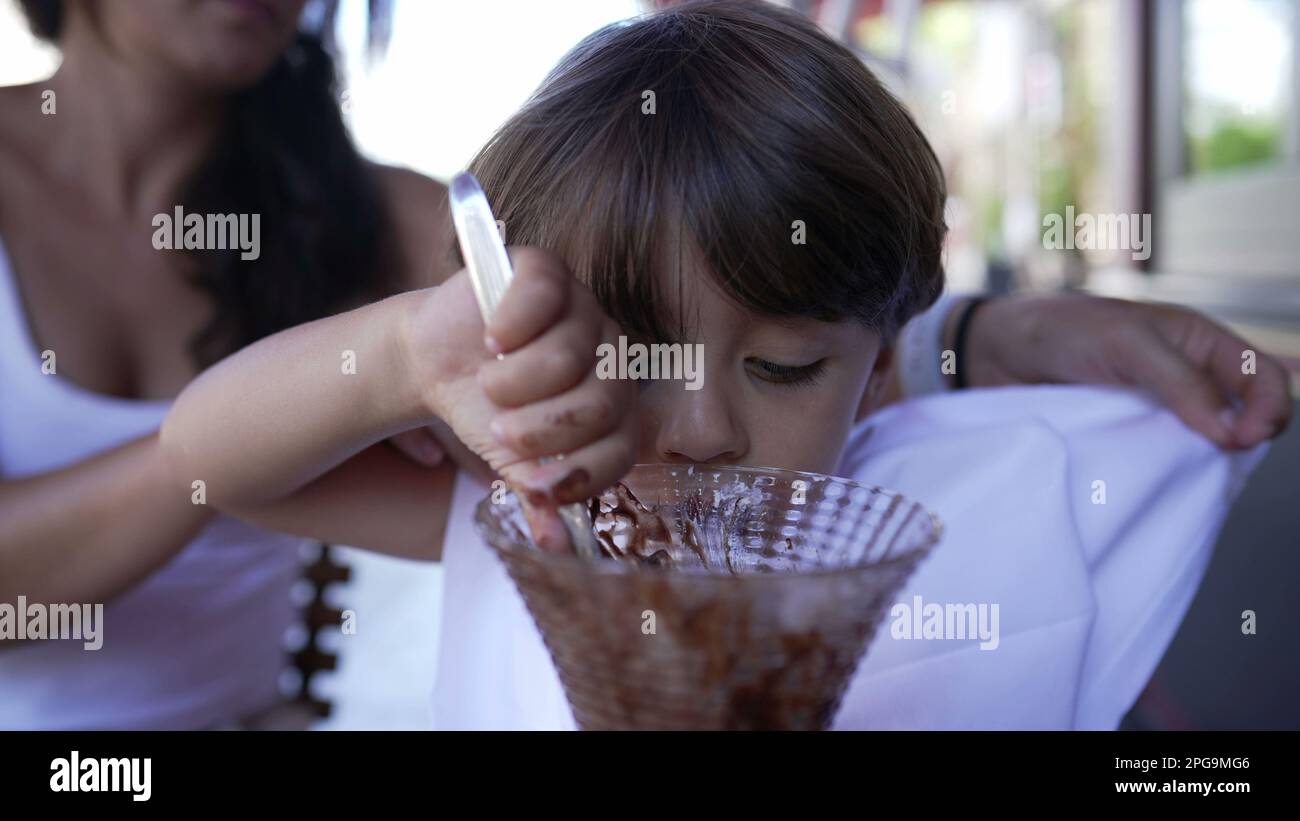 Mother putting napkin around child neck to protect from stains while ...
