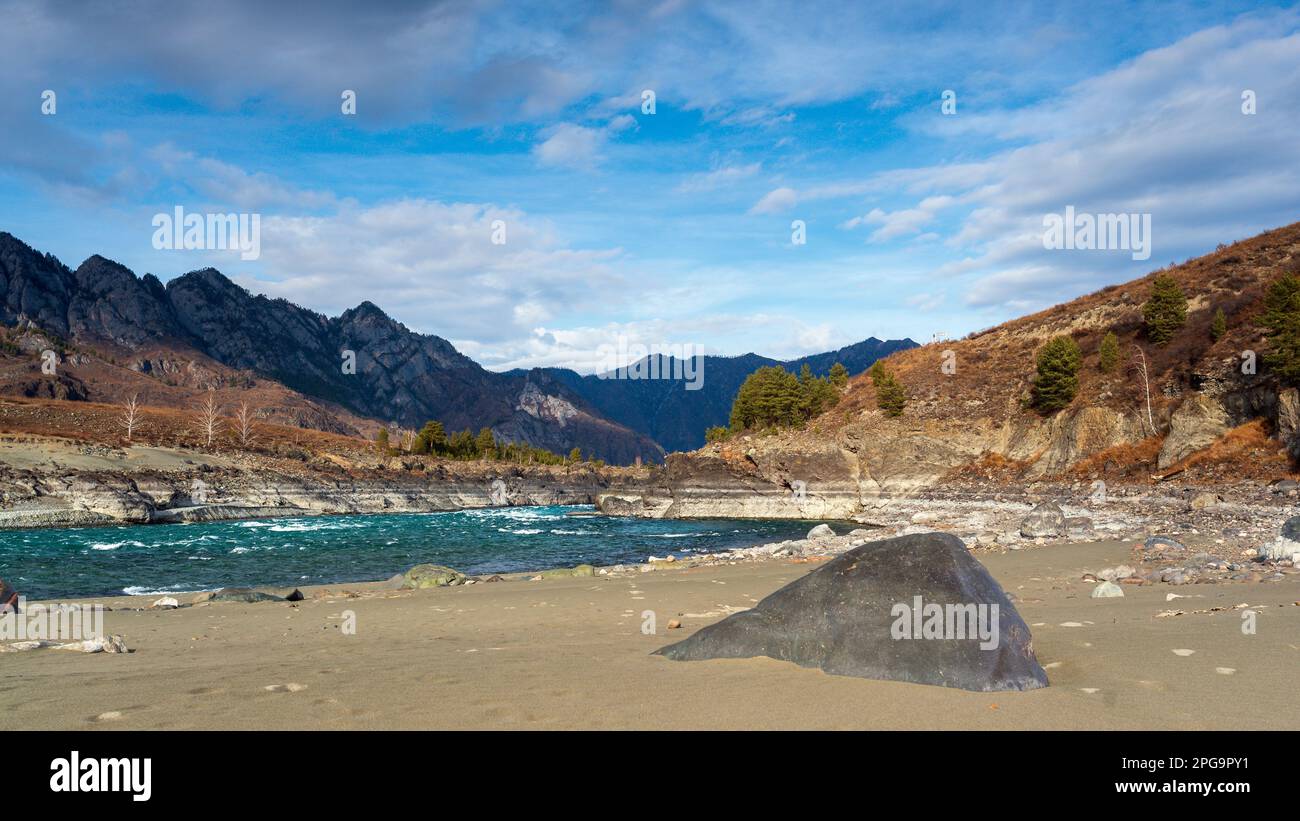 Landscape of a stone on a sandy beach near the fast river Katun in ...