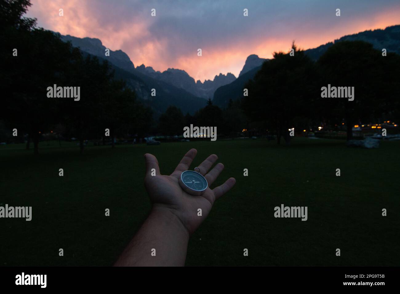 Compass held with one hand on a background mountain landscape. Concept ...