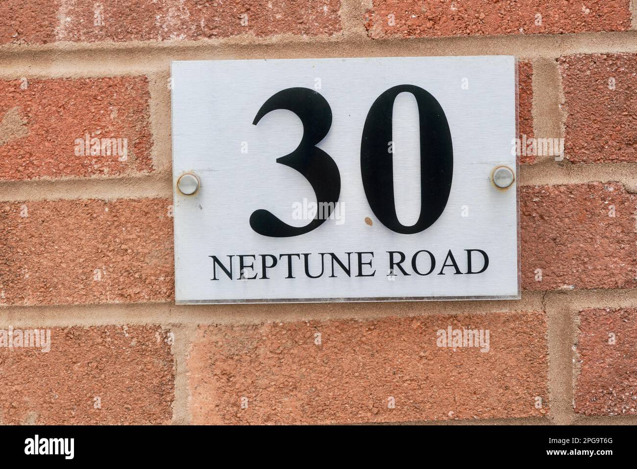 Door number 30, and street name Neptune Road in black on a white ...