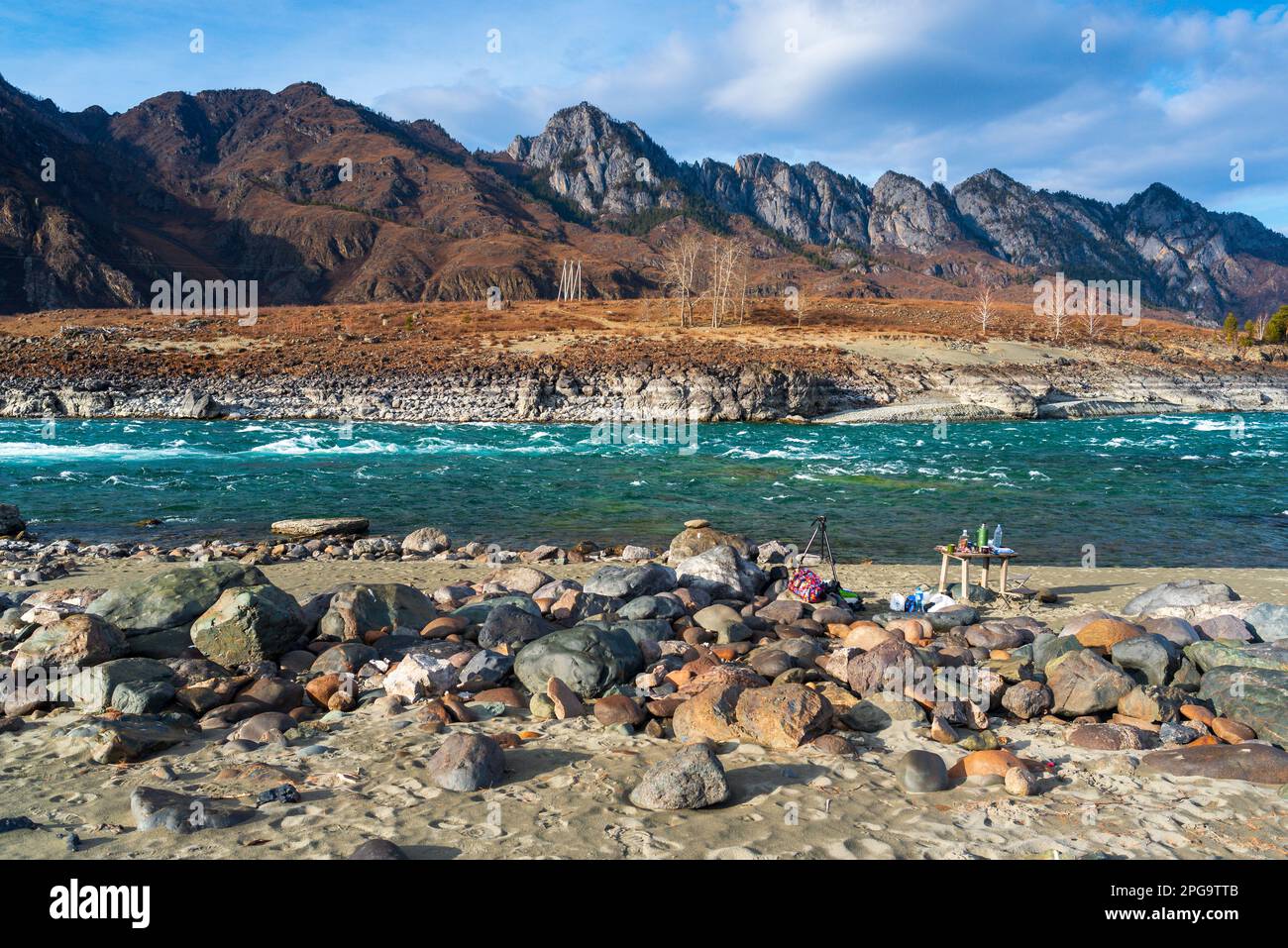 Tourist table with products on a sandy beach with stones near the ...