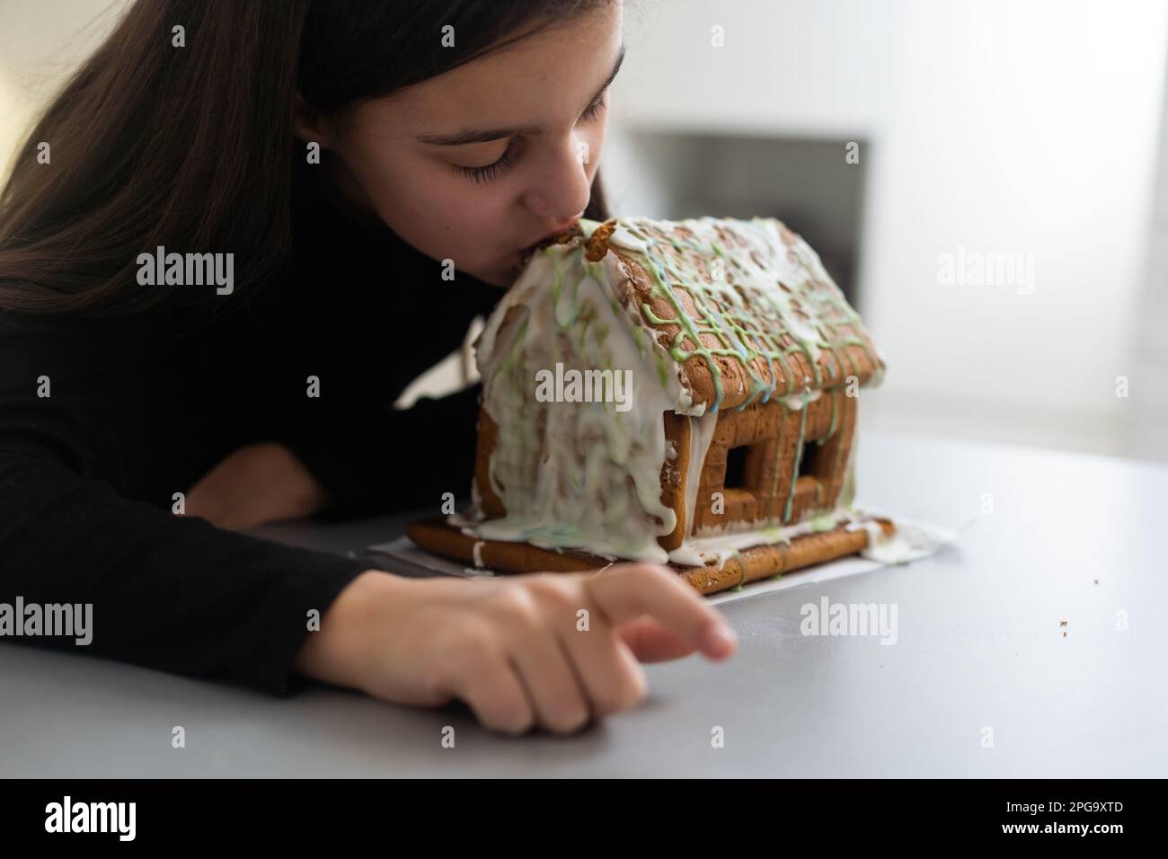 A teenage girl is eating a gingerbread house Stock Photo - Alamy