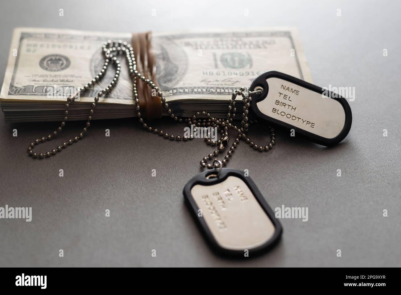 An army medallion rests on a hundred dollar bill. Concept: payment by a ...