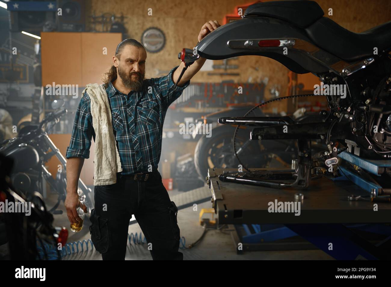 Custom motorcycles mechanic resting drinking beer in garage Stock Photo ...