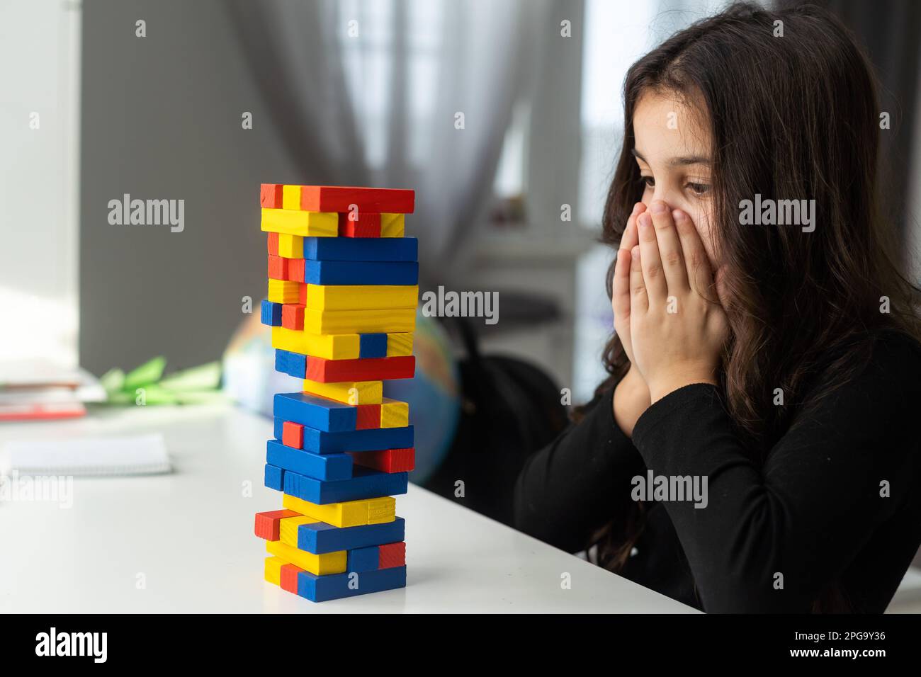 Cute little girl excites with wooden block game Stock Photo - Alamy