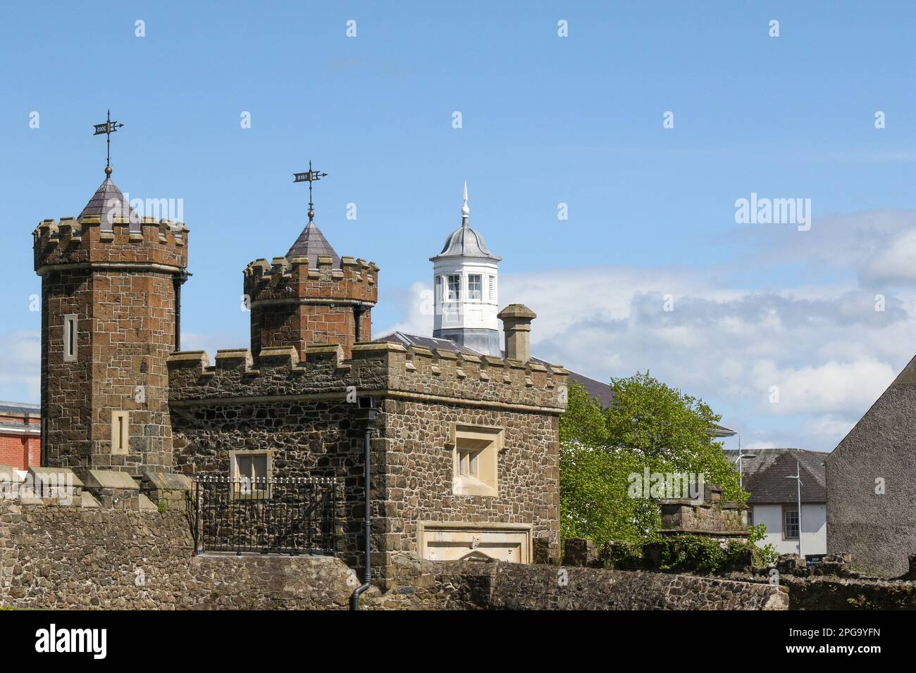 Sunny spring day Antrim town centre, battlement and stone facade of ...