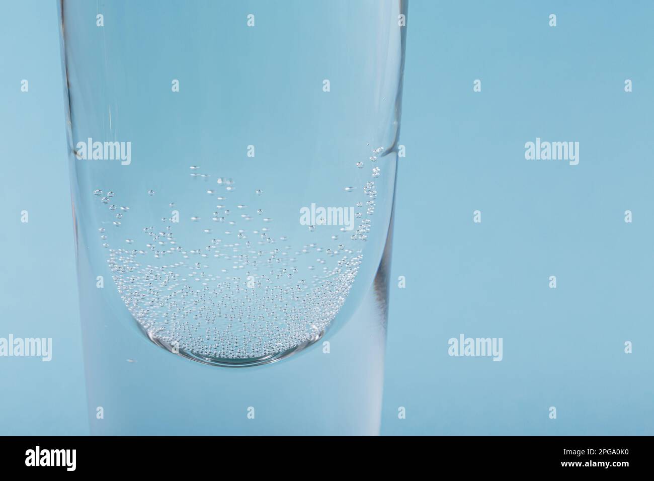 Glass of pure sparkling water on light blue background Stock Photo - Alamy