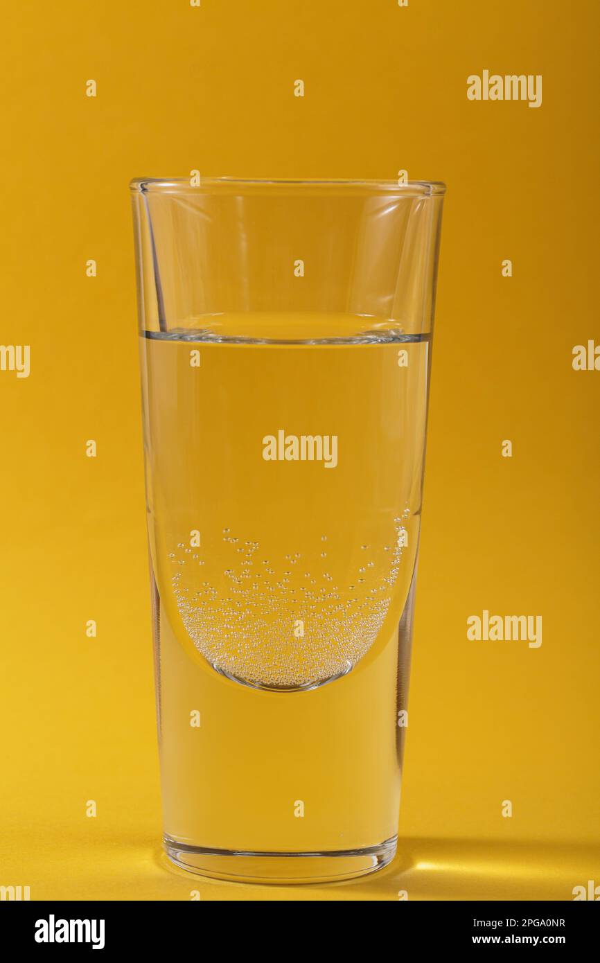 Glass of pure sparkling water on yellow background Stock Photo - Alamy