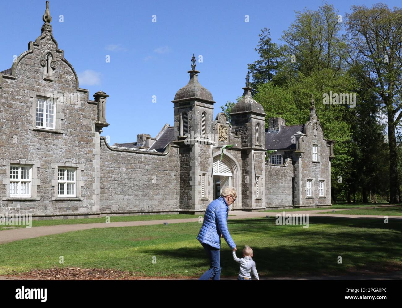 Woman and child walking in public park in spring sunshine outside ...