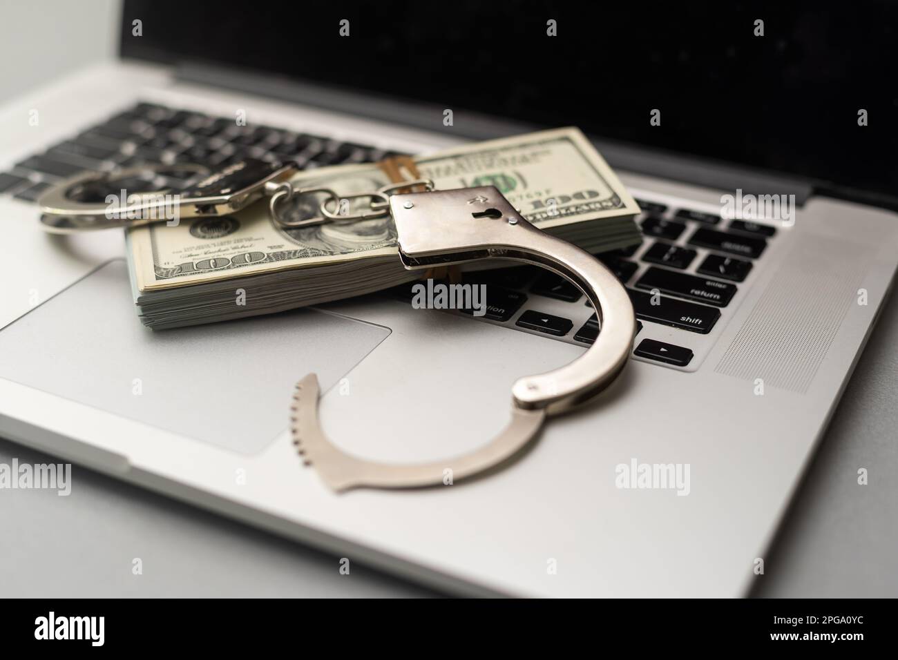 Cyber crime legal law police handcuffs on a hundred dollar bills with ...
