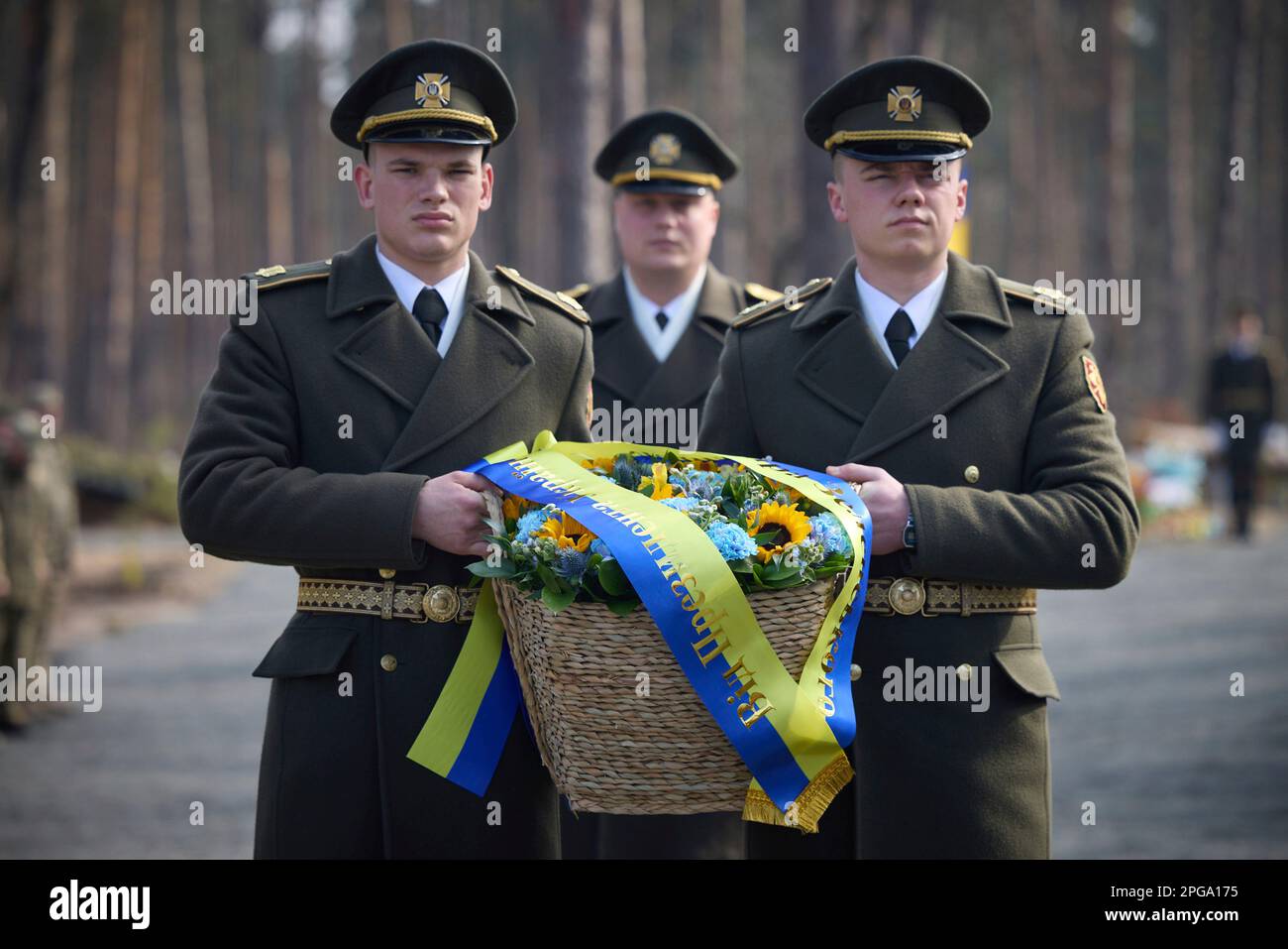 Moschun, Ukraine. 21st Mar, 2023. Ukrainian honor guards carry a basked ...