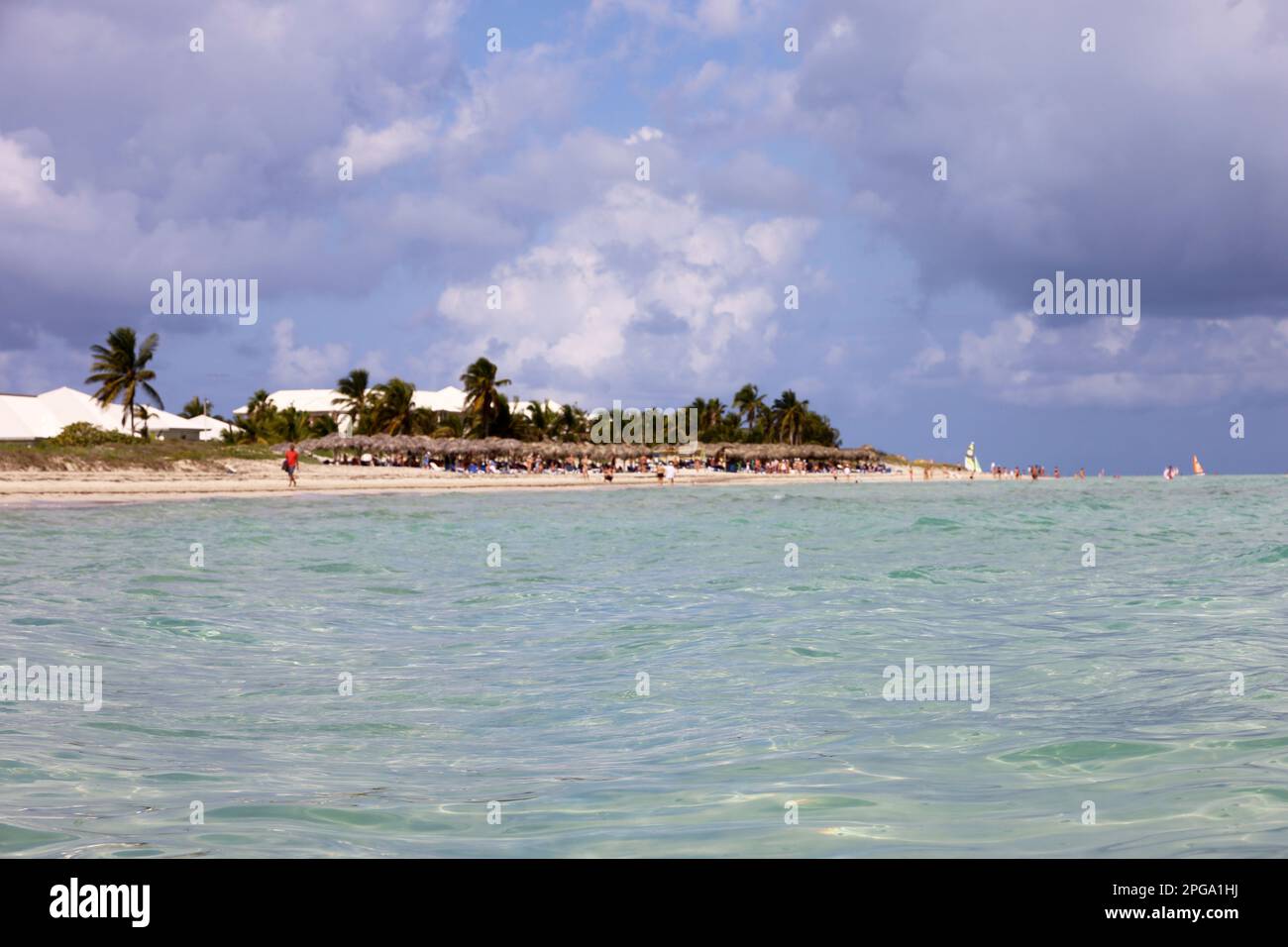 View from ocean waves to tropical beach with people, sandy coast and ...