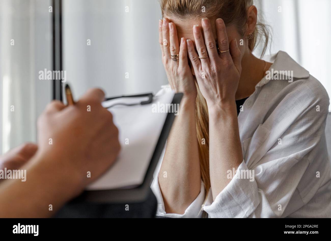A male psychologist consults a female patient, makes notes. A woman ...