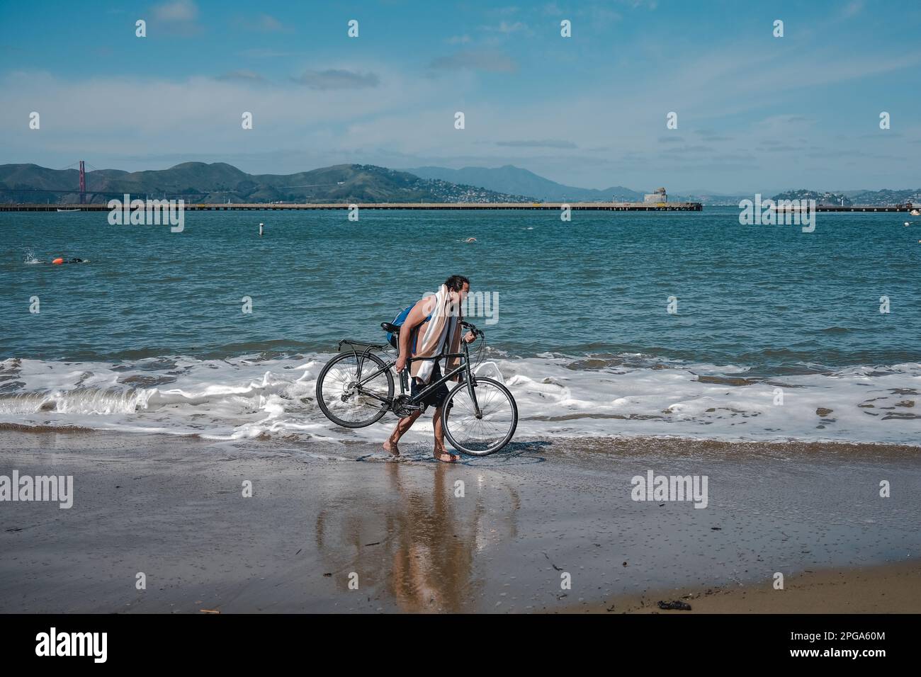 A man holds his bike along the beach outside the Ghirardelli Square. Ghirardelli Square, located ...