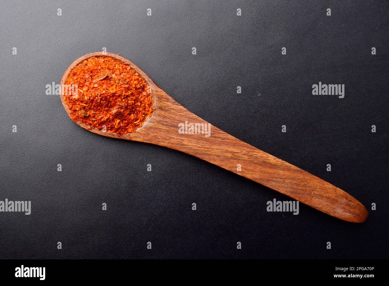 Top view of ground chili in spoon on dark background Stock Photo - Alamy