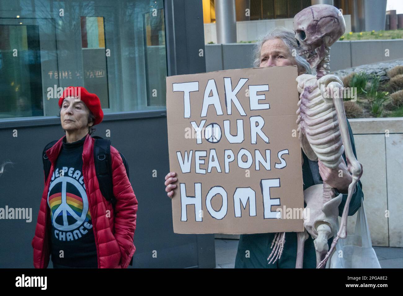 London, UK. 21 Mar 2023. A woman holds a poster and a skeleton at the ...