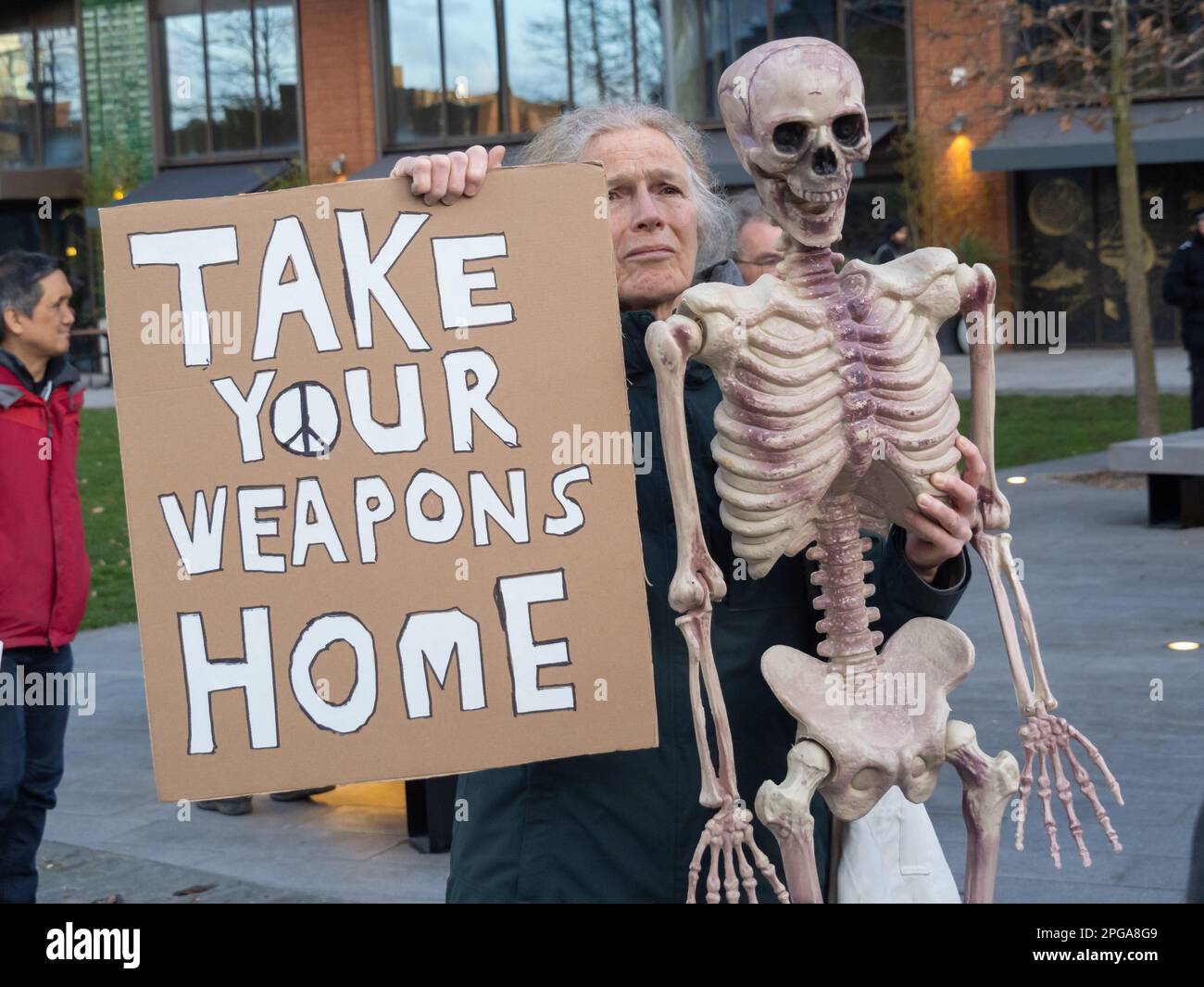 London, UK. 21 Mar 2023. A woman holds a poster and a skeleton at the ...