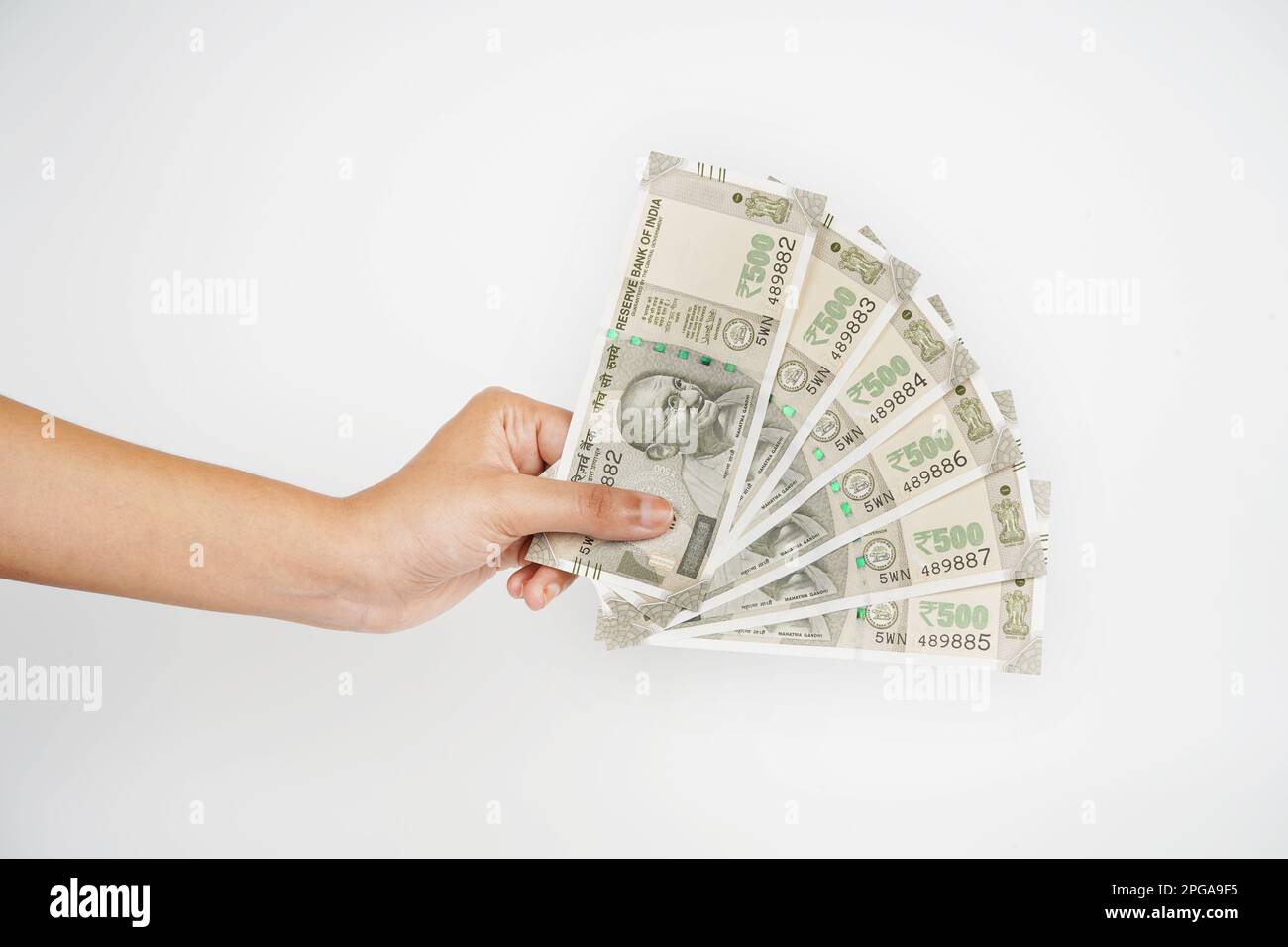 Indian rupee cash in hand on white background Stock Photo - Alamy