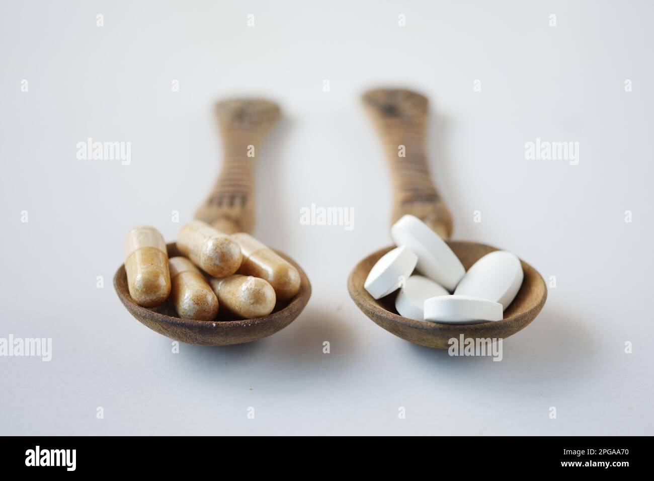 comparing herbal medicine capsule and medical pill on black Stock Photo ...