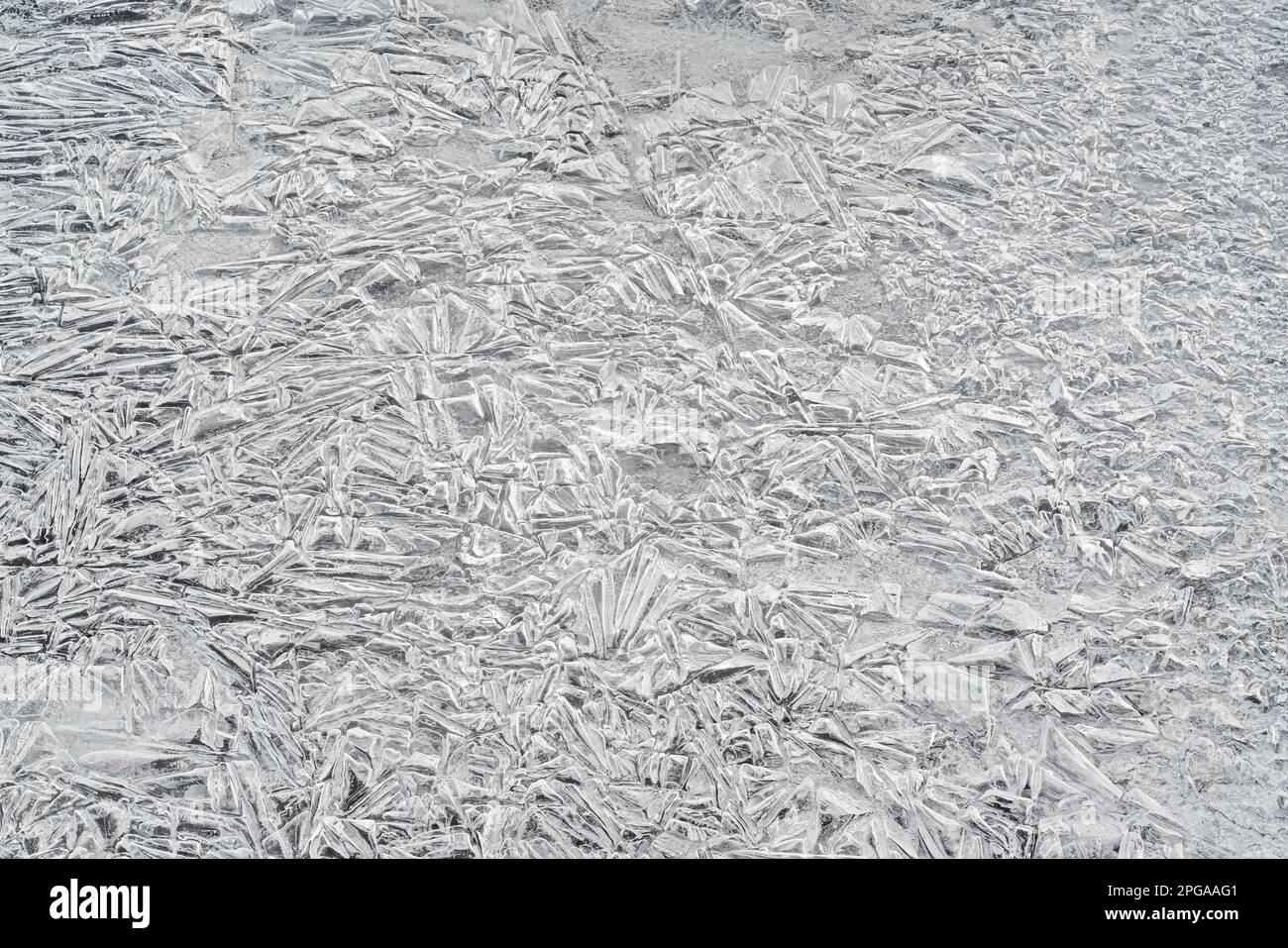 Ice on frozen river, trapped bubbles forming crystal like structures ...