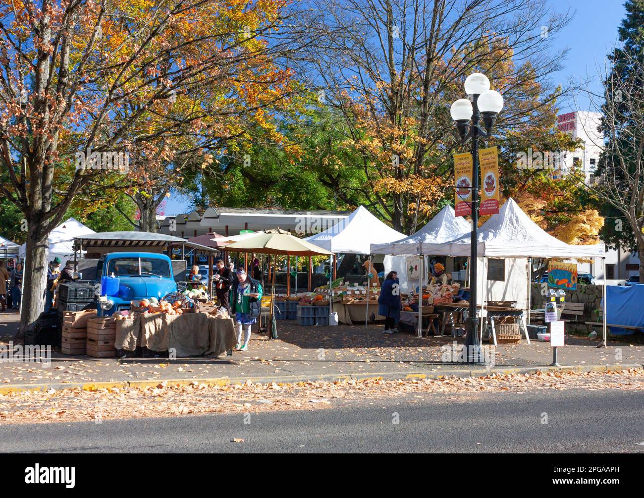 Farmer's market customers and vendors with produce and old truck on ...