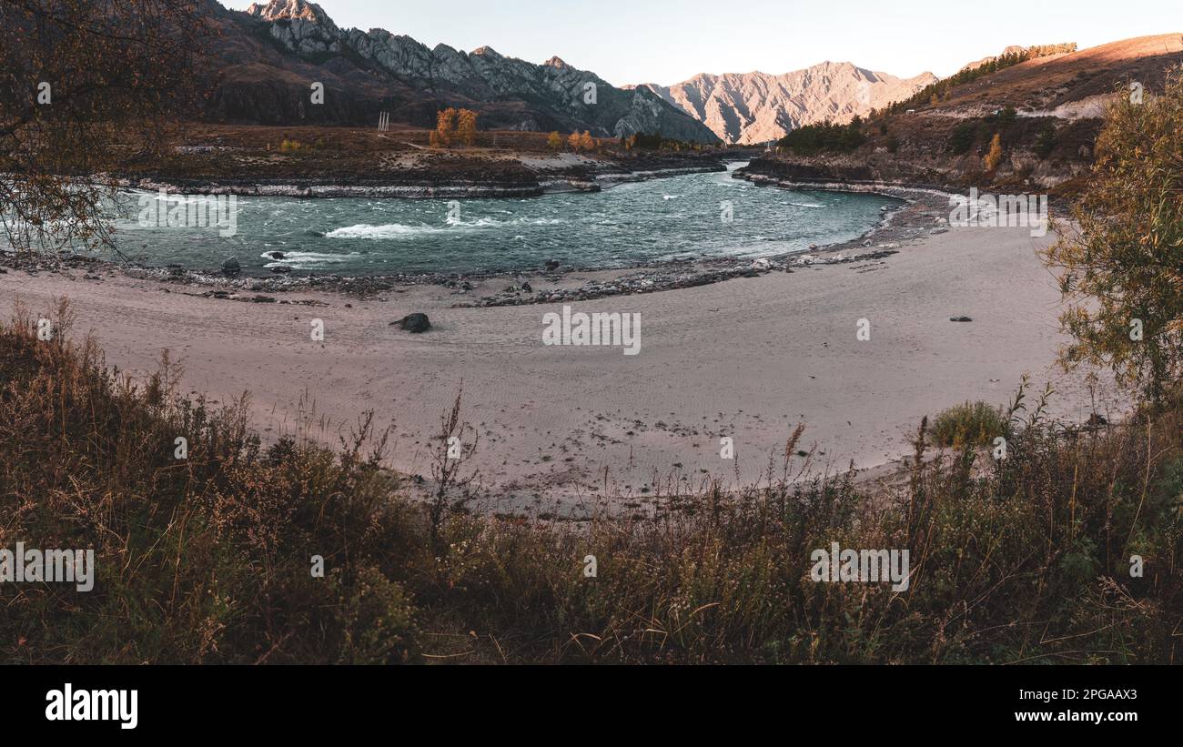 Panorama of a beach with sand and stones of the fast mountain river ...