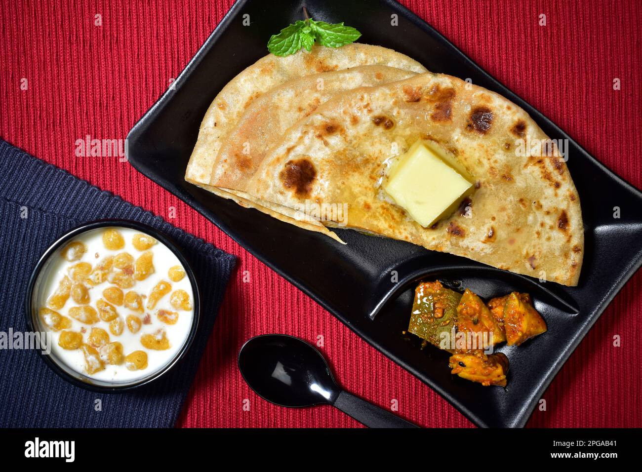 Top view of aloo paratha served with bundi raita and pickle Stock Photo ...