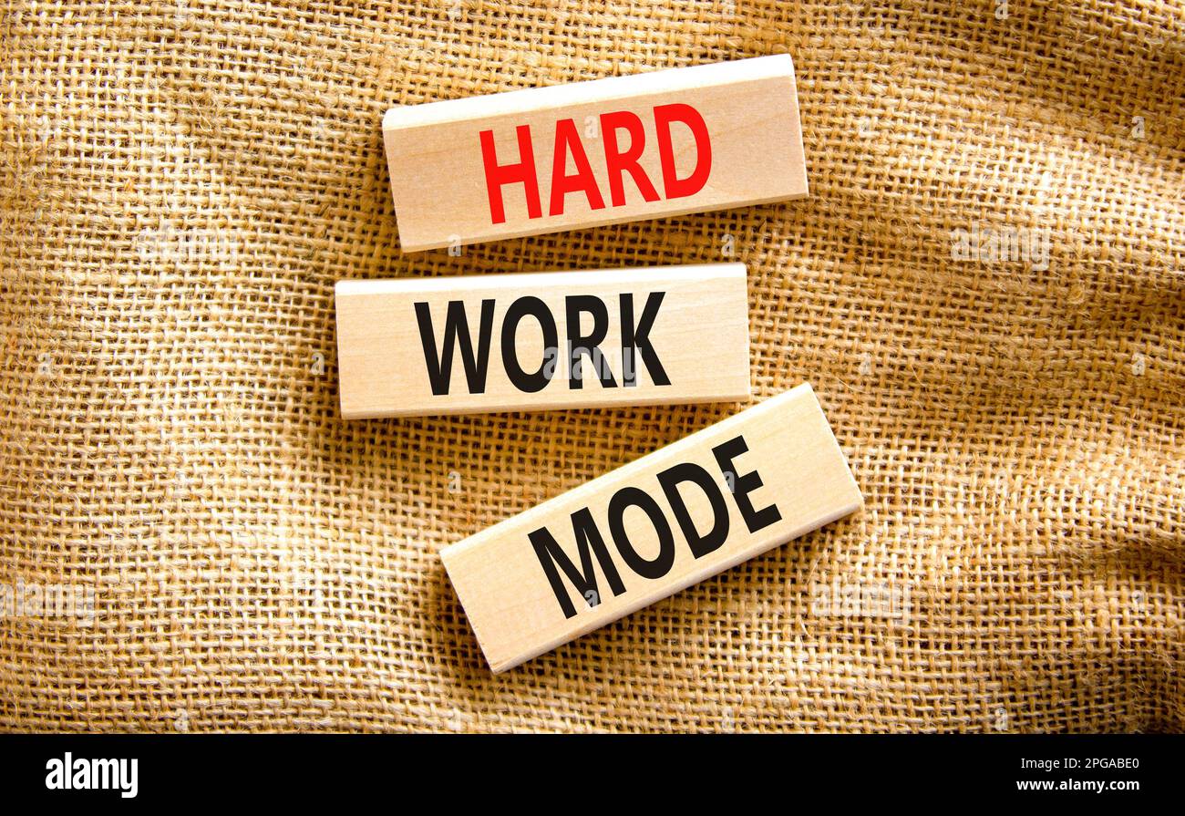 Hard work mode symbol. Concept words Hard work mode on wooden block on a beautiful canvas table ...