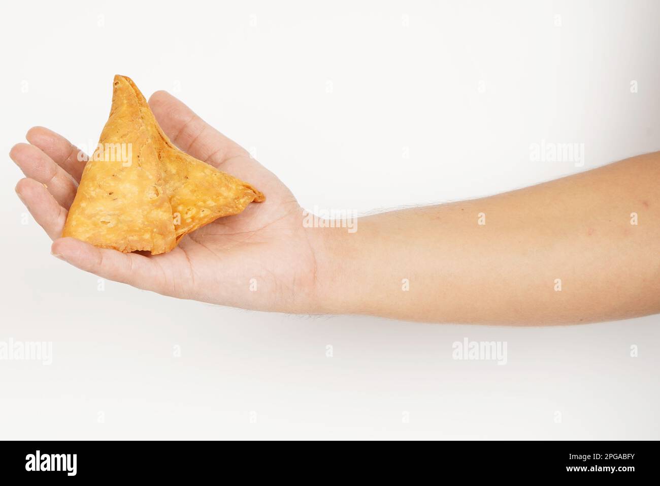 Samosa in hand isolated on white background, triangle snack Stock Photo ...