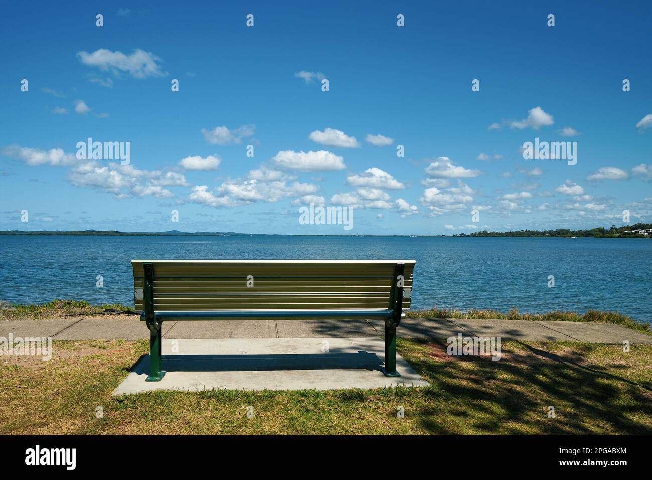 Empty bench seat looking out over the waters of southern Moreton Bay to ...