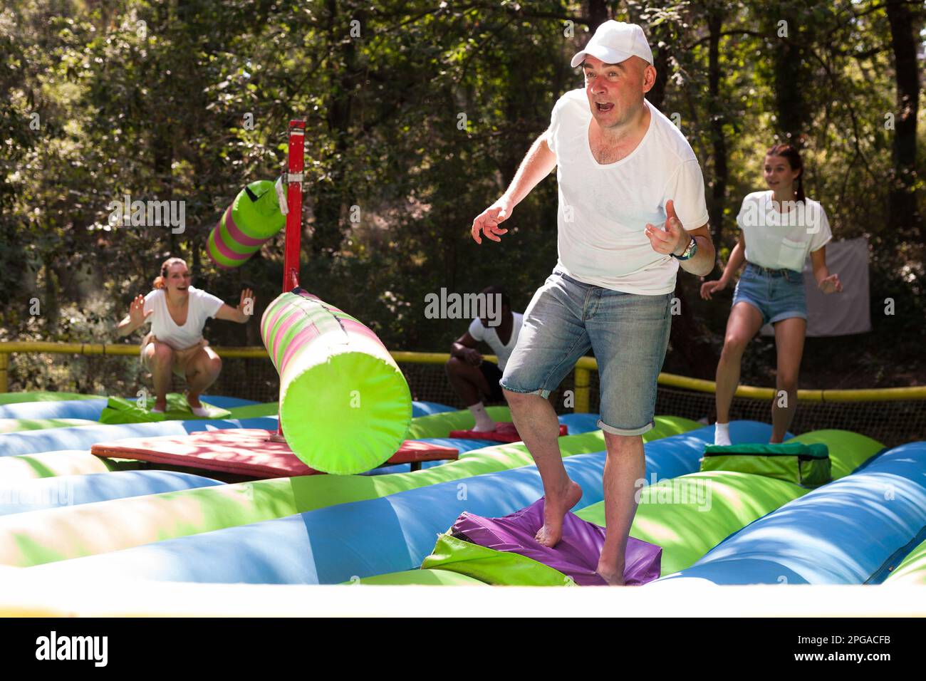 Funny adult friends are jumping on an inflatable trampoline Stock Photo ...