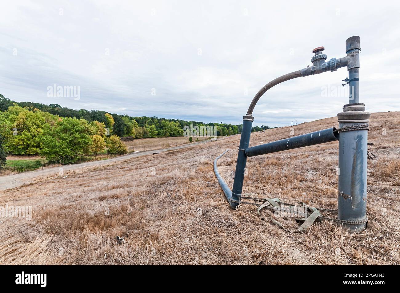 A vertical landfill methane gas wellhead and valve at an active ...
