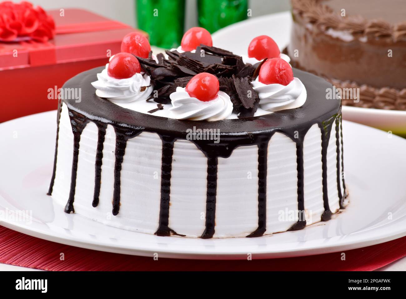 Chocolate and vanilla cake with red cherry Stock Photo - Alamy