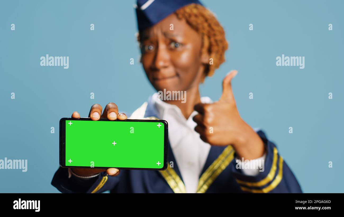 Female aircrew member pointing at greenscreen display over blue ...