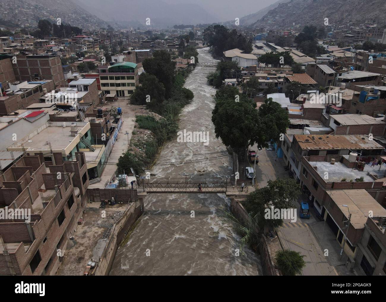 A woman walks on a bridge over the Rimac River, a day ahead of World ...