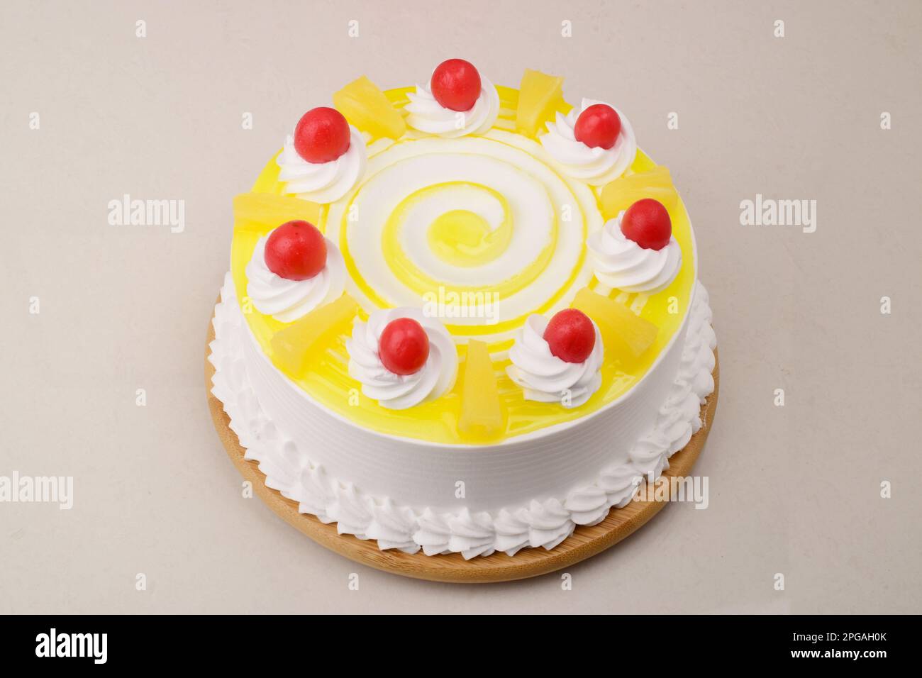 Mango vanilla cake with red cherry, whole cake Stock Photo - Alamy