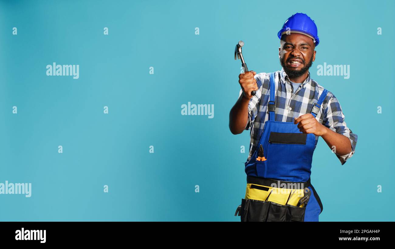 Construction worker hitting something with hammer, using manual ...