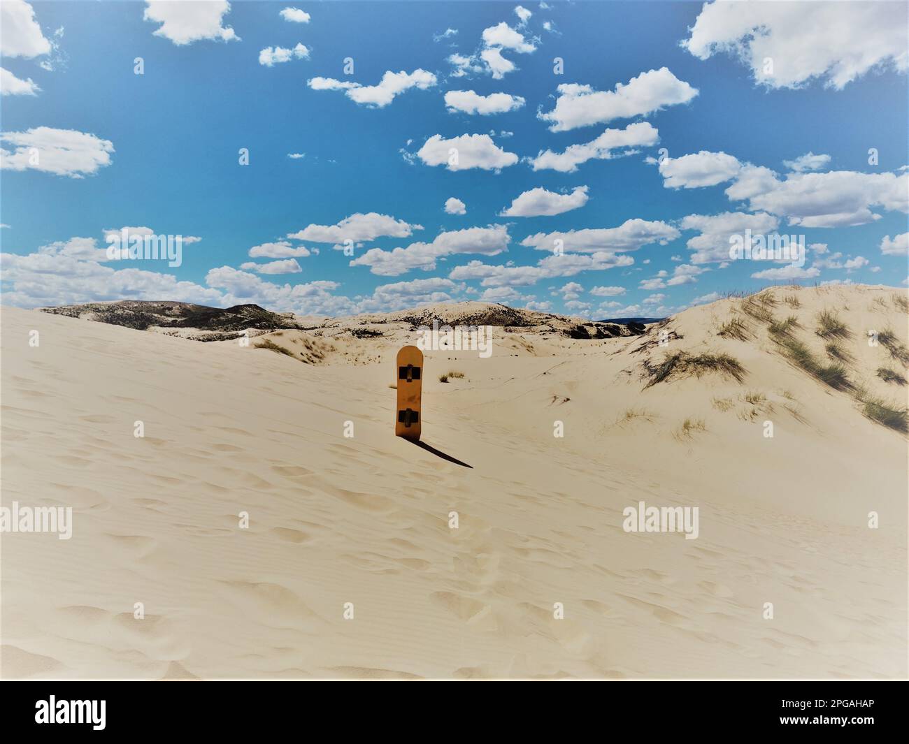 A lone skateboard stuck in a sand of a sandy desert landscape Stock ...
