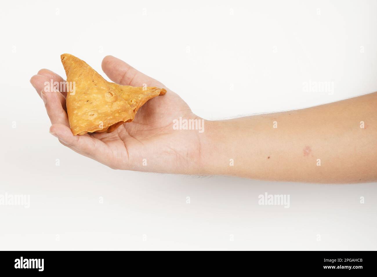 Samosa in hand on white background Stock Photo - Alamy