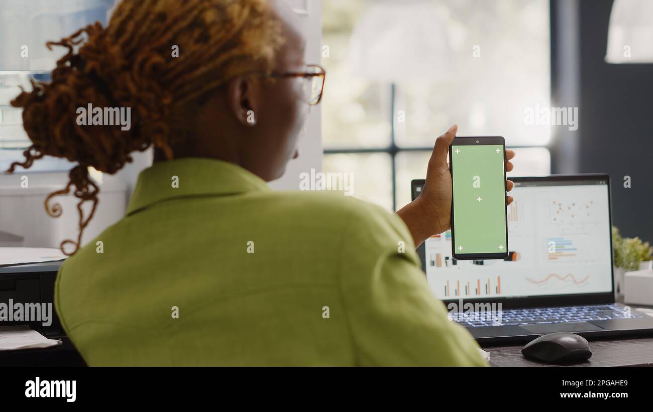 Female Manager Looking At Greenscreen Display In Office Working With