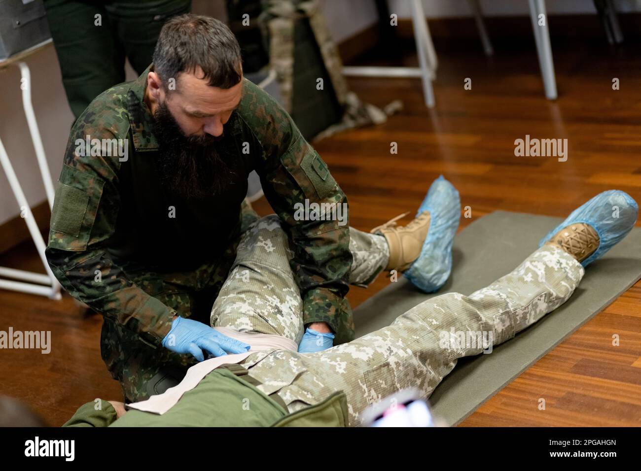 A 40-year-old bearded military medic demonstrates how to pack a wound ...