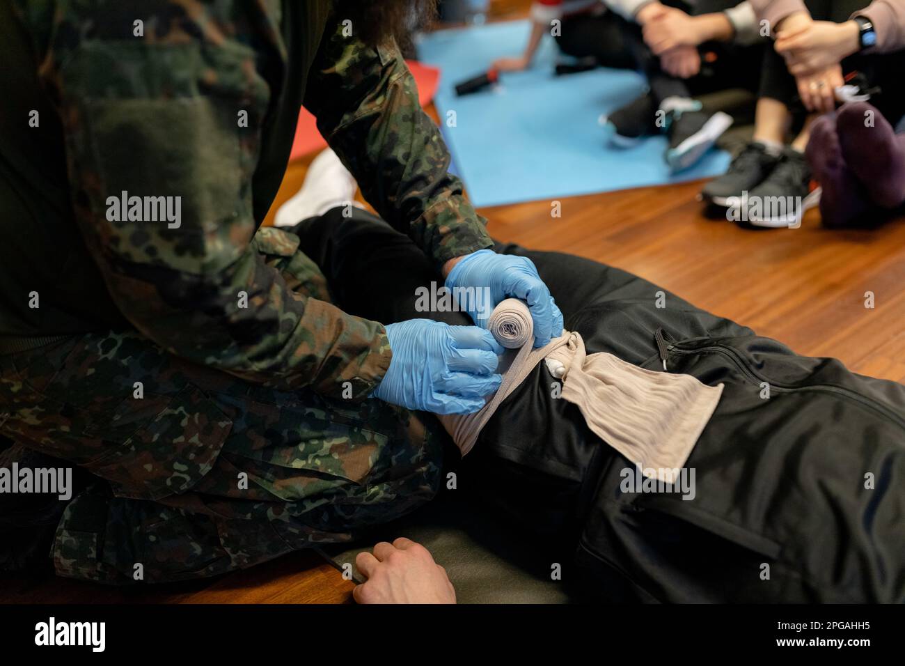 A 40-year-old bearded military medic demonstrates how to tampon a wound ...