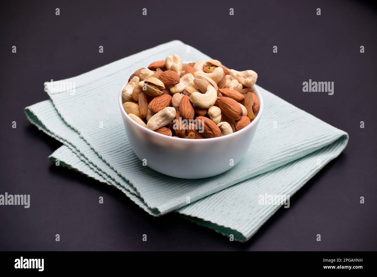 Mix nuts in bowl, cashews and almonds mix with pistachios and raisins ...