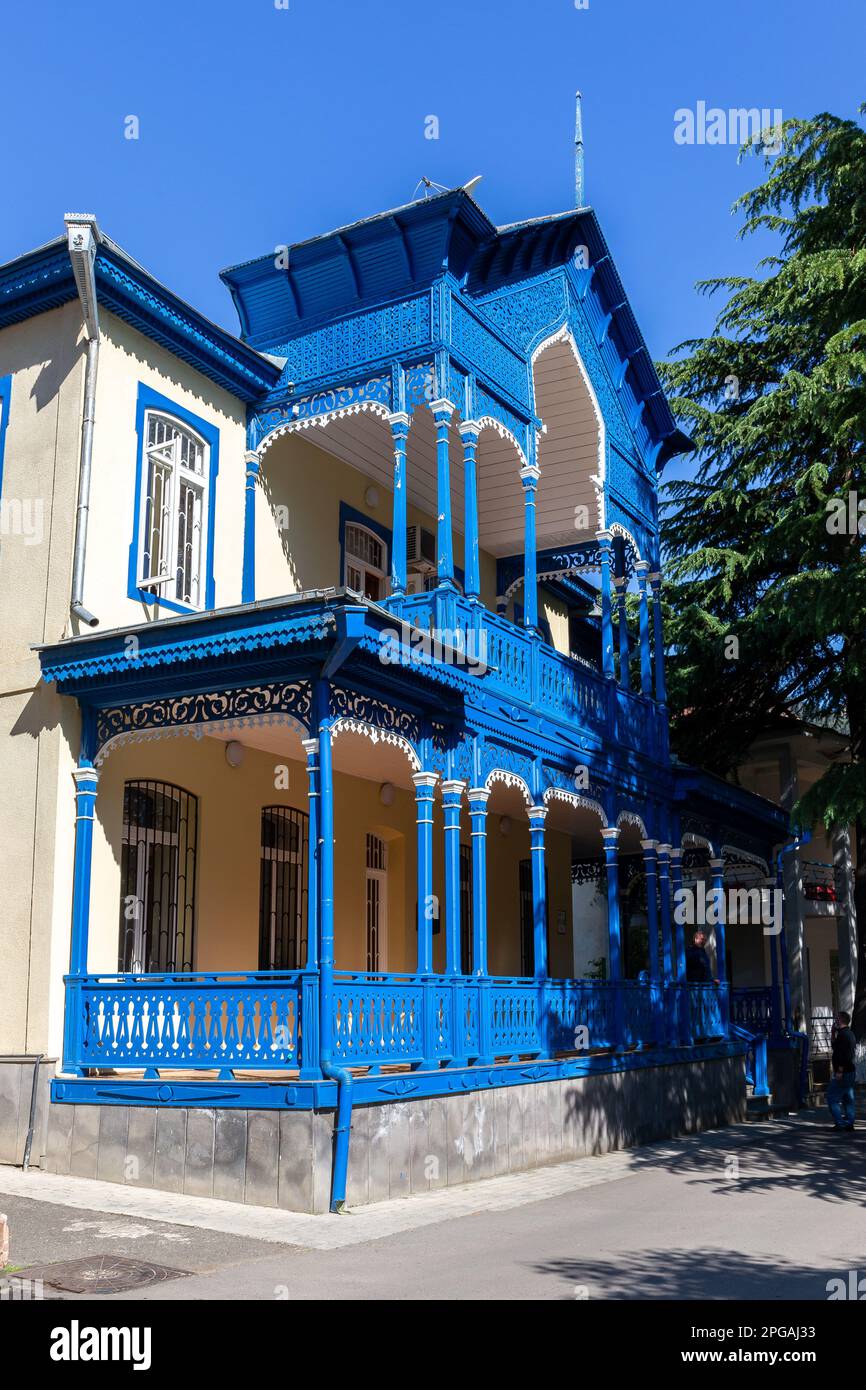 Traditional Borjomi building facade with blue carved wooden balcony and ...