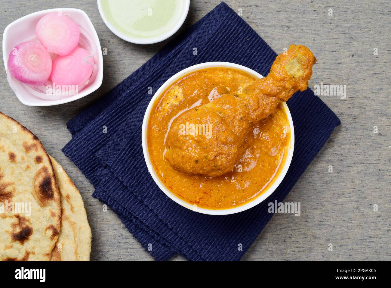 Butter chicken in bowl served with roti and onion chutney Stock Photo ...
