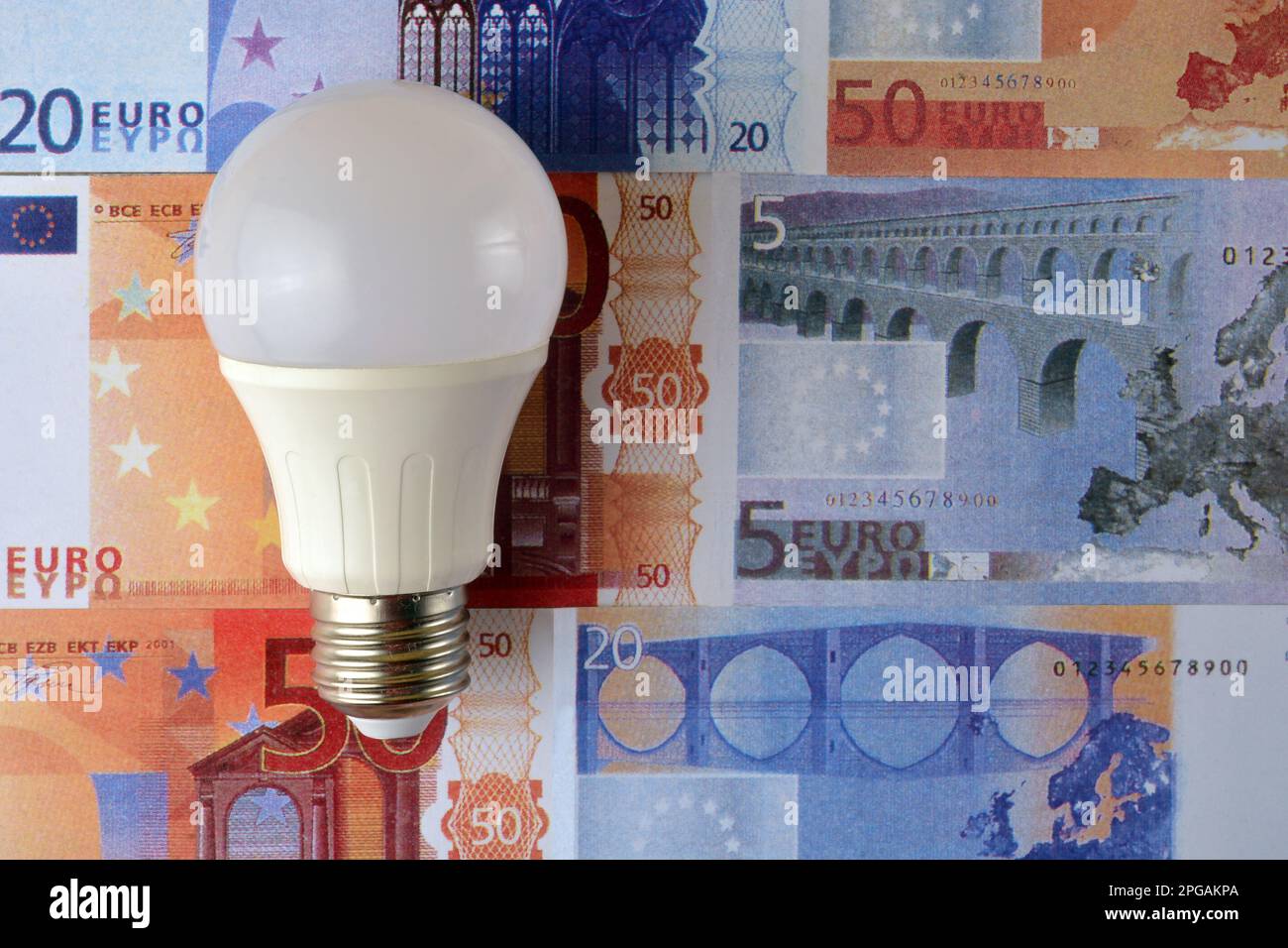 A low consumption led light bulb on a background of euro banknotes ...